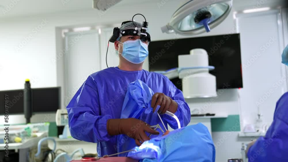 Confident otolaryngology surgeon quickly moving tool in patient’s nose ...