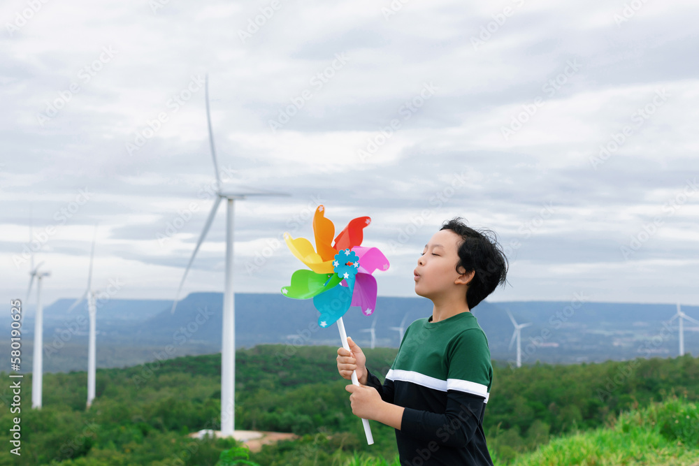 Progressive young asian boy playing with wind pinwheel toy in the wind ...