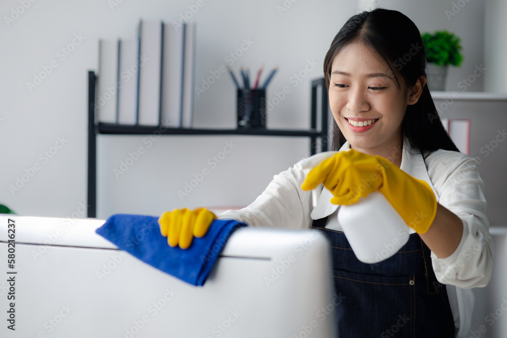 Person cleaning room, cleaning worker is using cloth to wipe computer ...