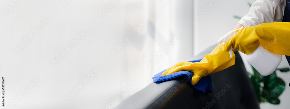 Person cleaning the room, cleaning staff is using cloth and spraying ...