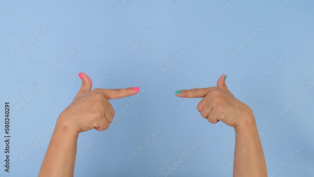 Female hands clapping and pointing with index finger on pastel blue ...