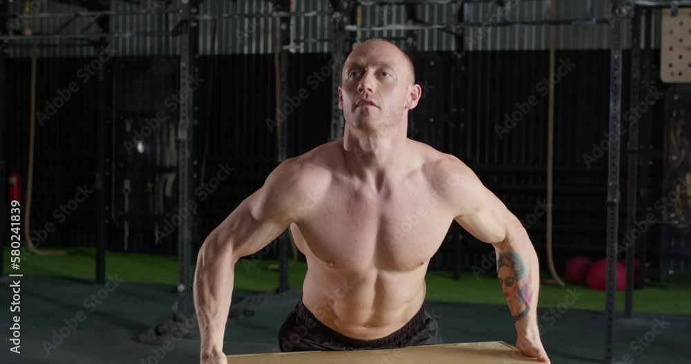strong athlete lifting wooden box at gym Muscular shirtless guy with ...