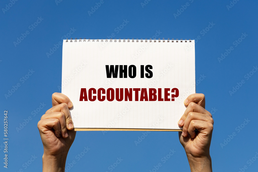 Who is accountable text on notebook paper held by 2 hands with isolated ...