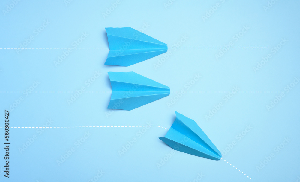 Three paper airplanes are moving forward, one turned sideways ...