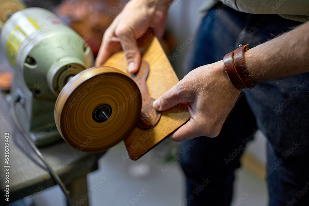 man smoothing and polishing leather cut, close up cropped side view ...