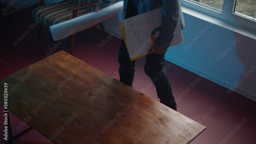 A man works lays out documents on the table at home. Folded paper ...