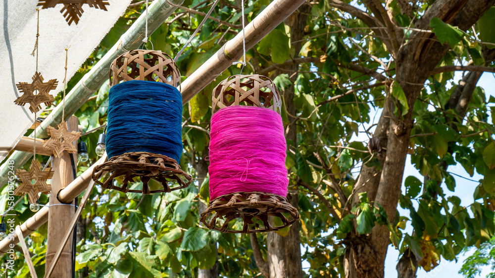 Spool of thread hanging mobile with tree background. Colorful bobbin ...