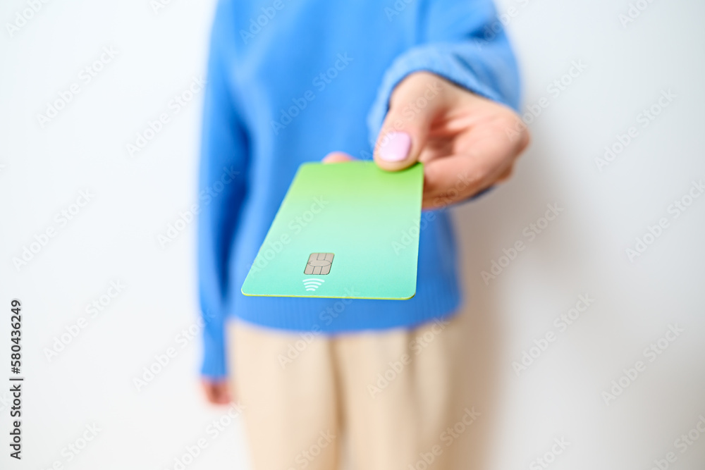 Unrecognizable female holds out her green gradient credit card to make ...