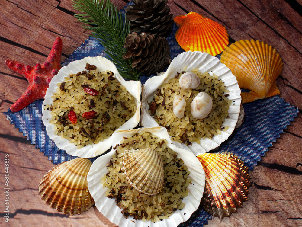 risotto di mare servito su conchiglie sopra tavolo con stella marina ...