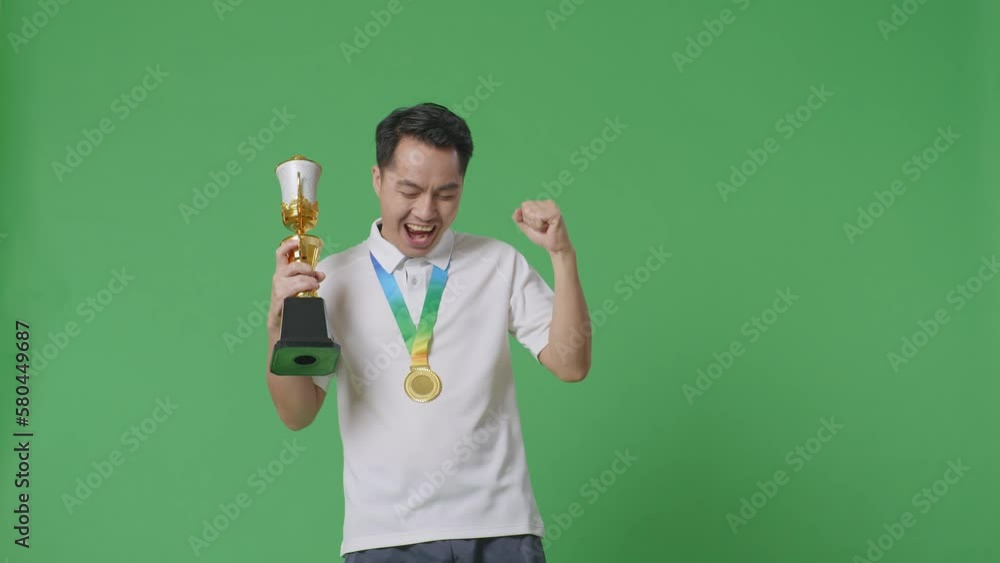 Asian Man With A Gold Medal Looking At A Gold Trophy Then Celebrating ...