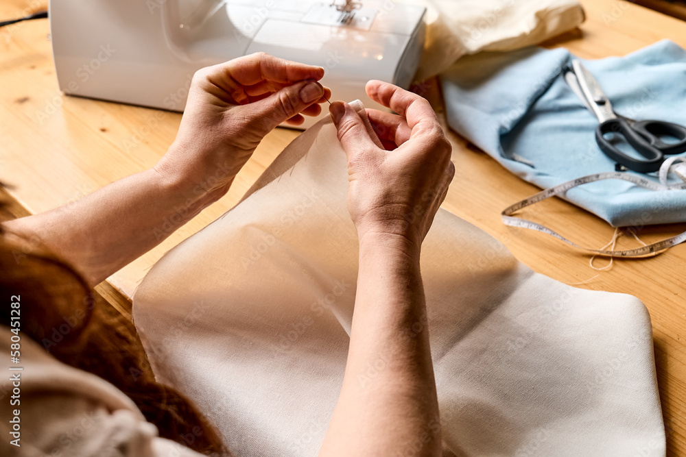 Seamstress basting and sewing in a small studio. Sartorial clothes ...