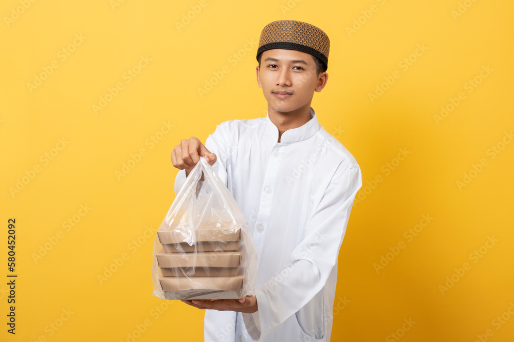 Young handsome asian muslim man giving alms or charity standing over ...