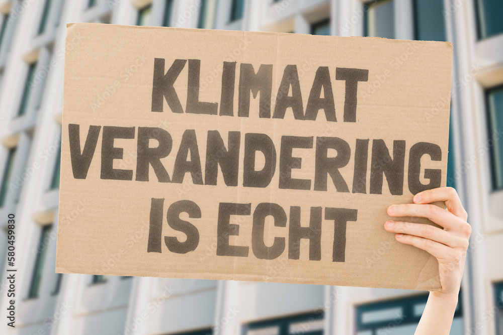 The phrase " Climate change is real " drawn on a carton banner in men's ...