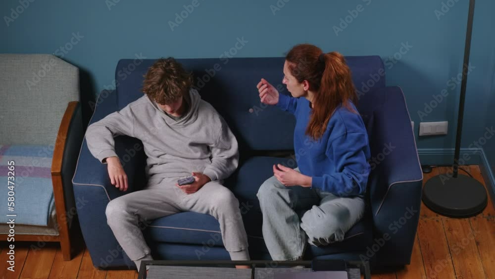 Mom Screams And Scolds Her Son In The Room On The Blue Sofa Irritated
