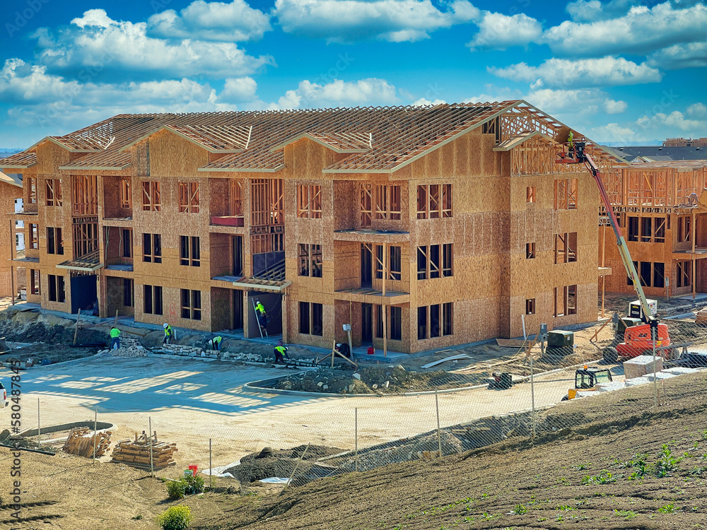 Hard working team constructing multi-family housing apartments ...