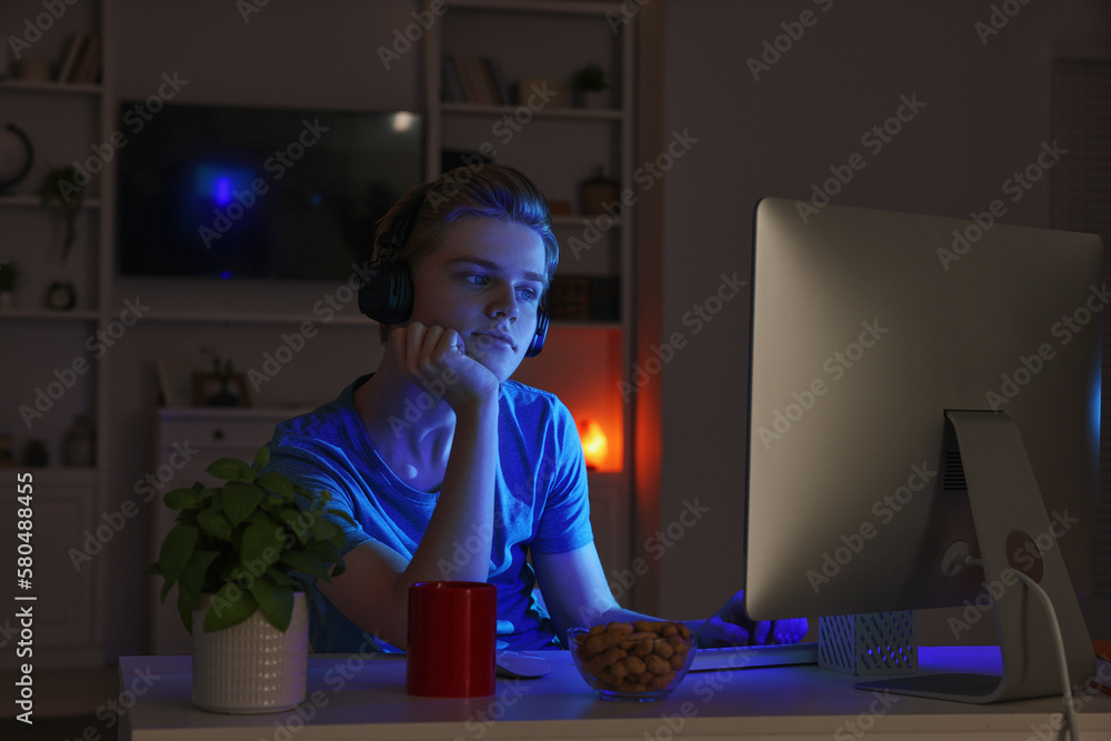 Teenage boy using computer in bedroom at night. Internet addiction ...