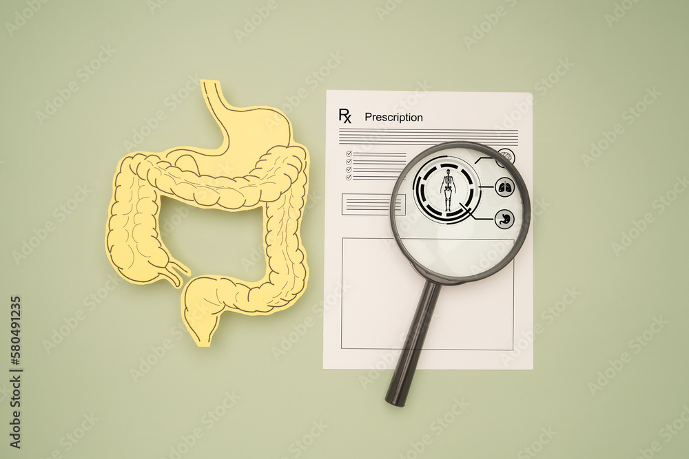 Top view of an intestine symbol made from yellow paper and a magnifying ...