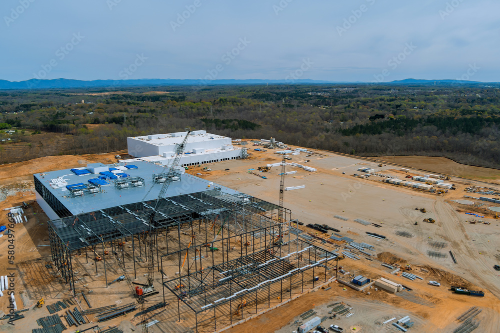 An industrial building is constructed use crawler cranes metal steel ...