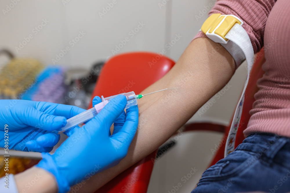 Preparation for blood test with pretty young woman by female doctor ...