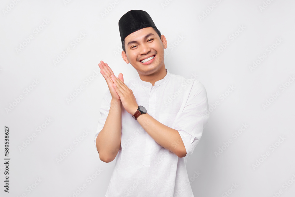 Smiling young Asian Muslim man clapping hands, celebrating success with ...