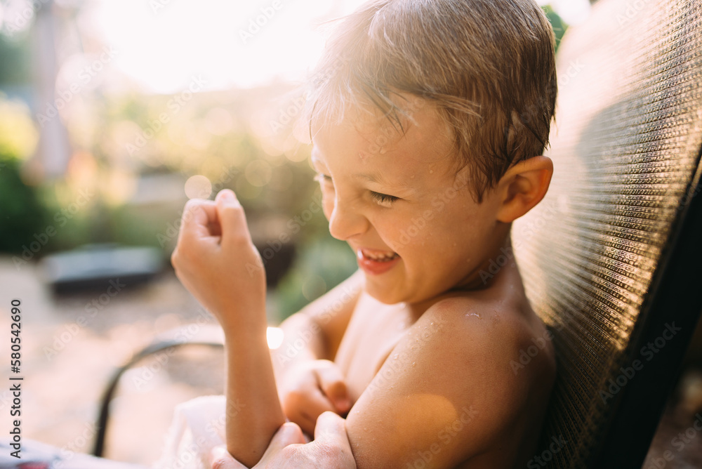 Shirtless boy being tickled while sitting on chair Stock Photo | Adobe ...