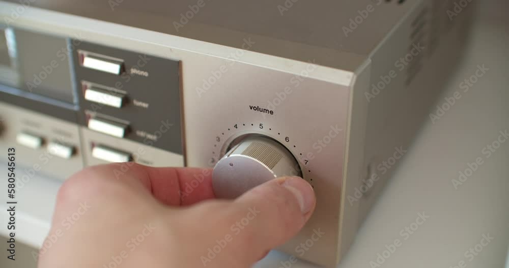 High angle close up shot of adjusting the volume knob on a stereo ...