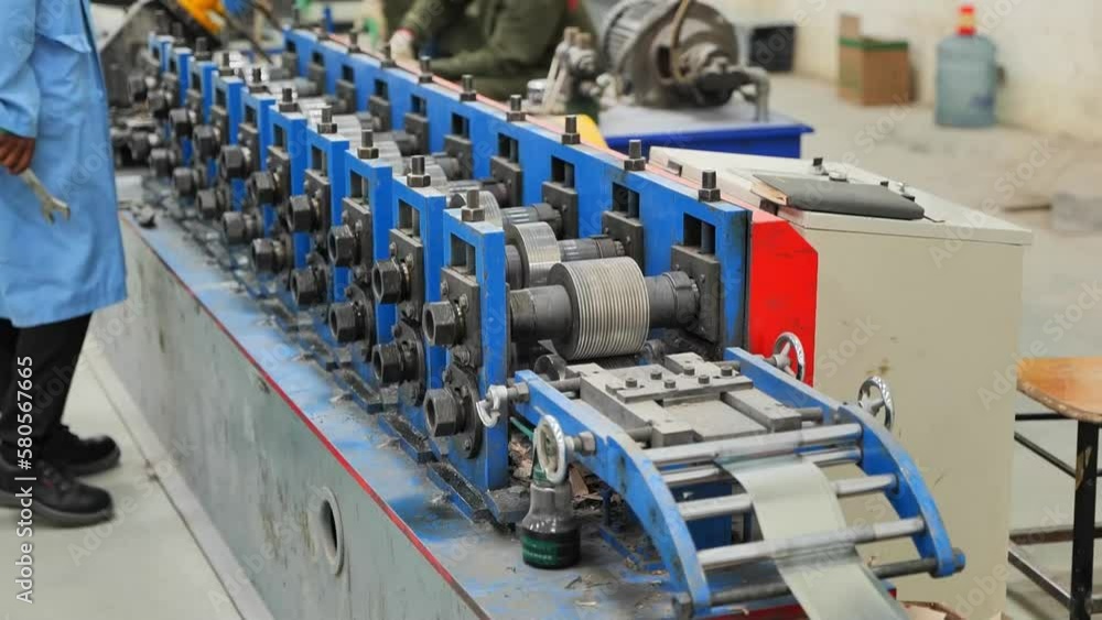 close-up sliding shot of a conveyor belt of a metal press from which a ...
