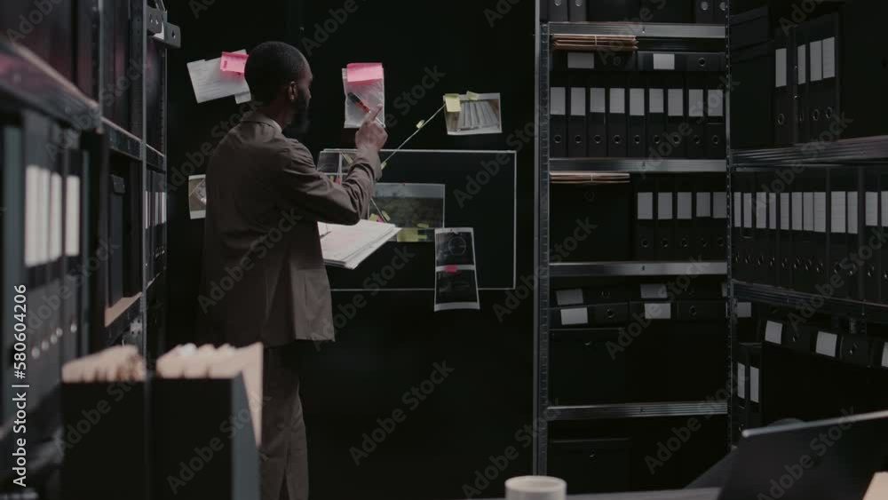 Young policeman examining detective map with evidence, trying to solve ...