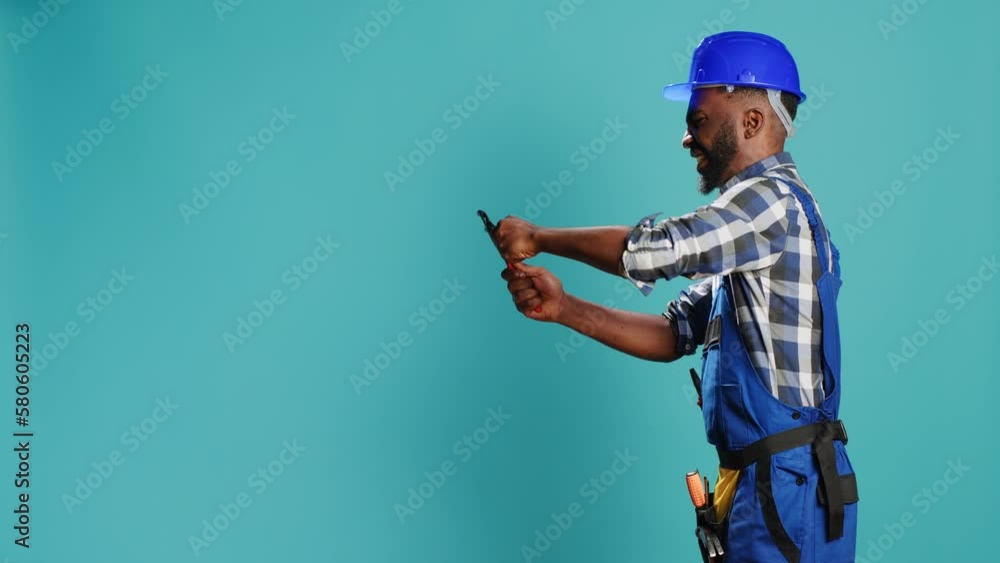 Construction worker clamping something with wrench in studio, using ...