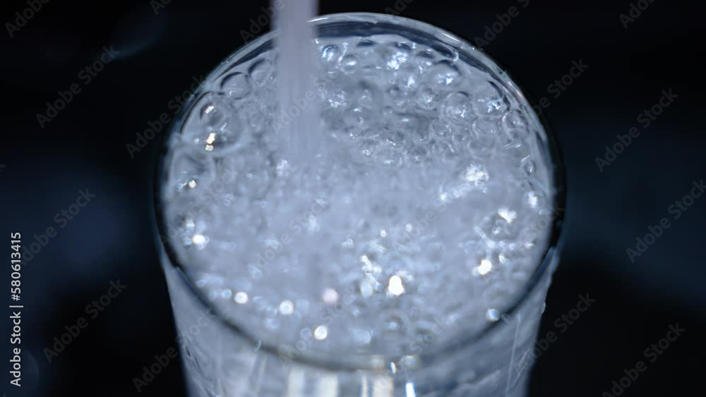 Clean drinking water from the tap. Glass of water close-up, slow motion ...