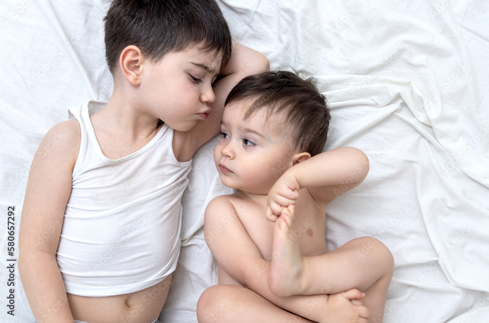 emotional photo with two brothers lying on bed hugging kiss each other cuddling and caresses.big ...