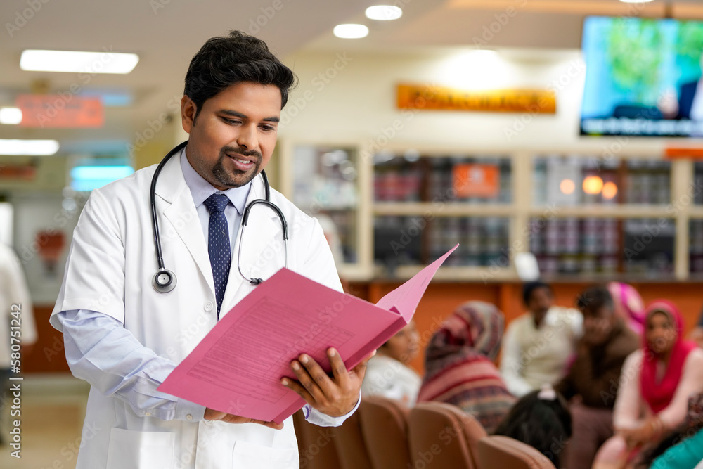 Young indian doctor watching medical report at hospital. Stock Photo ...
