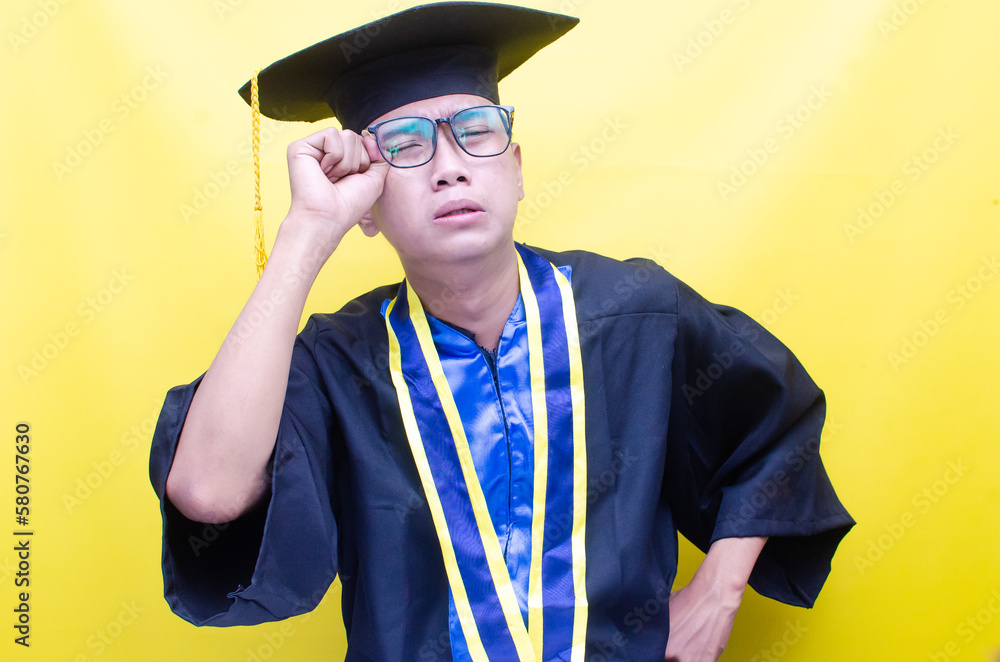 sad Asian man in graduation cap and gown rubbing his tears. student ...