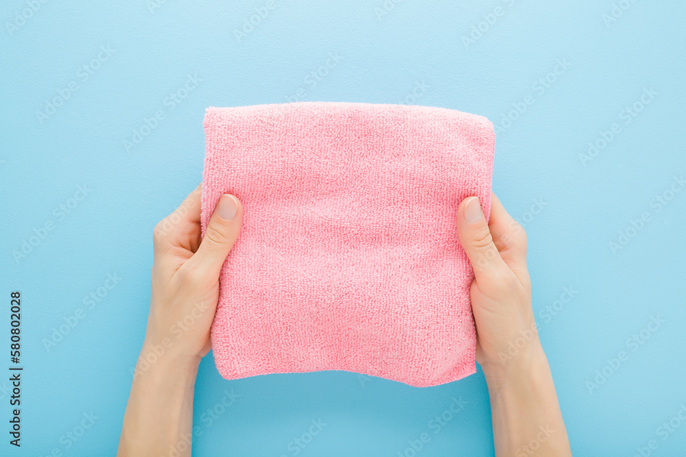 Young adult woman hands holding pink folded dry soft microfiber rag for ...