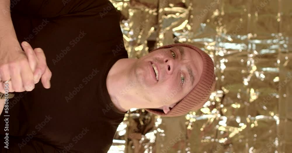 Inspired man makes a video vertically golden background. Eyes wide open ...