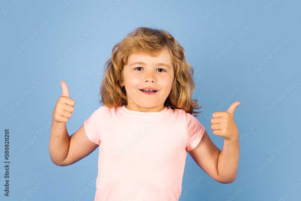 Child showing thumbs up on studio isolated background. Portrait of kid ...