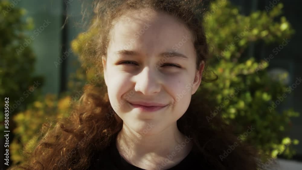 Close up portrait child smiles at camera. Happy child in park ...