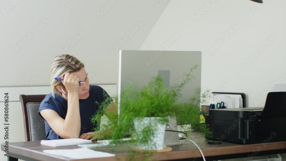 tired bored female in blue sit desk computer monitor woman hold pen ...