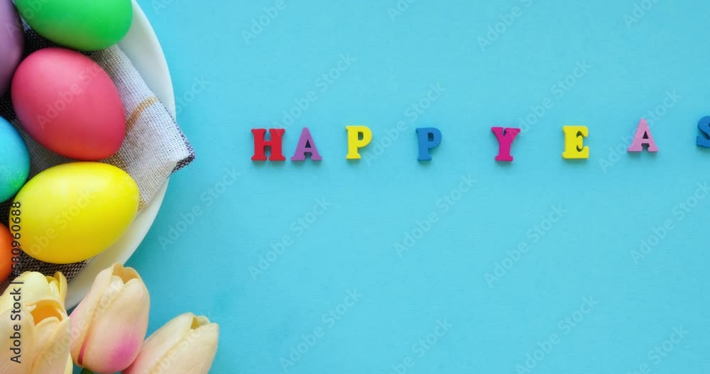 Basket with easter colored eggs, tulips and inscription happy easter ...