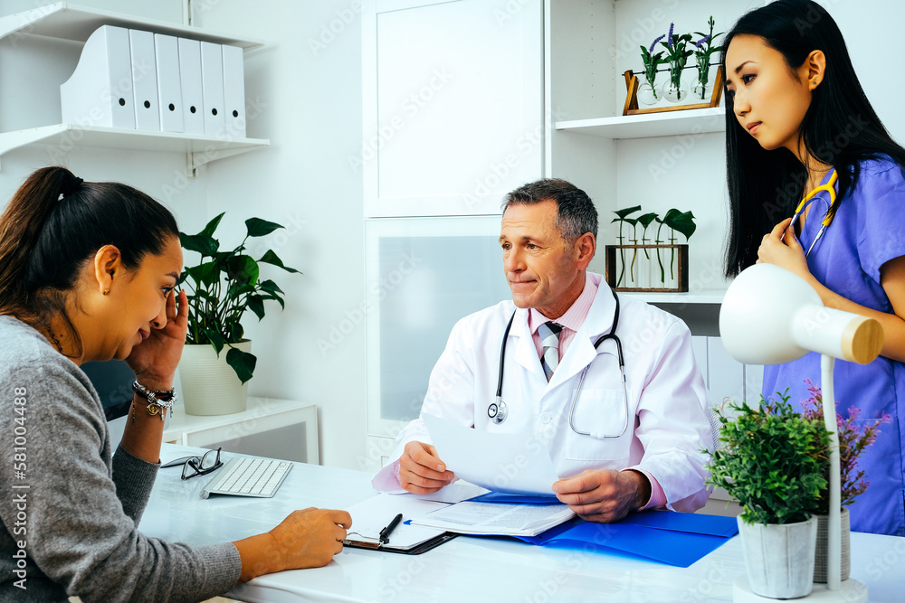 Concerned doctor talking to upset patient with nurse Stock Photo ...