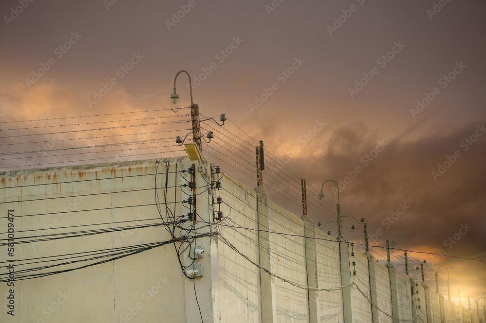 Prison security electric fence and high concrete wall. Prison high ... Prison security electric fence and high concrete wall. Prison high ...