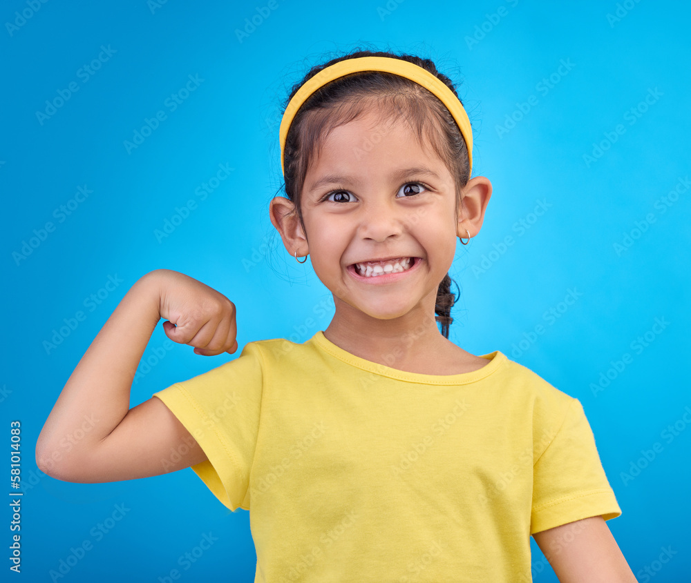 Strong, happy and portrait of a child with muscle isolated on a blue ...