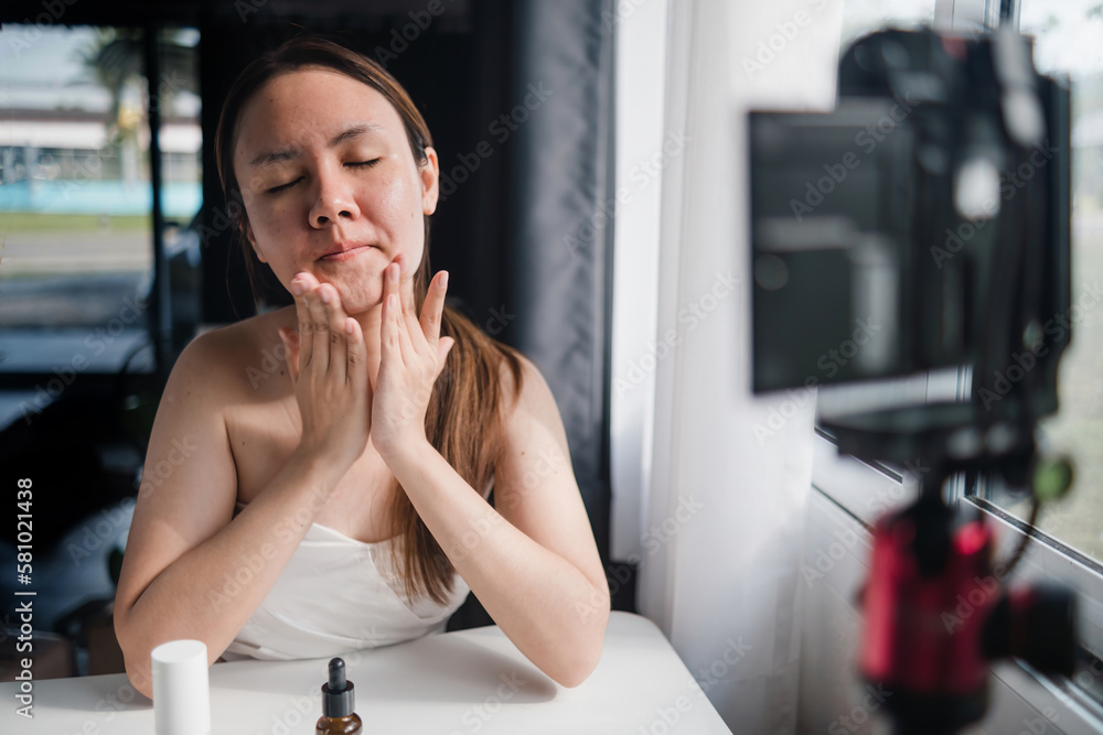 Asian female influencer demonstrating how to apply creams and ...