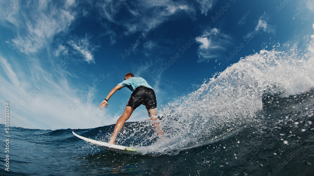 Surfer rides the wave. Young man aggressively surfs the ocean wave in ...