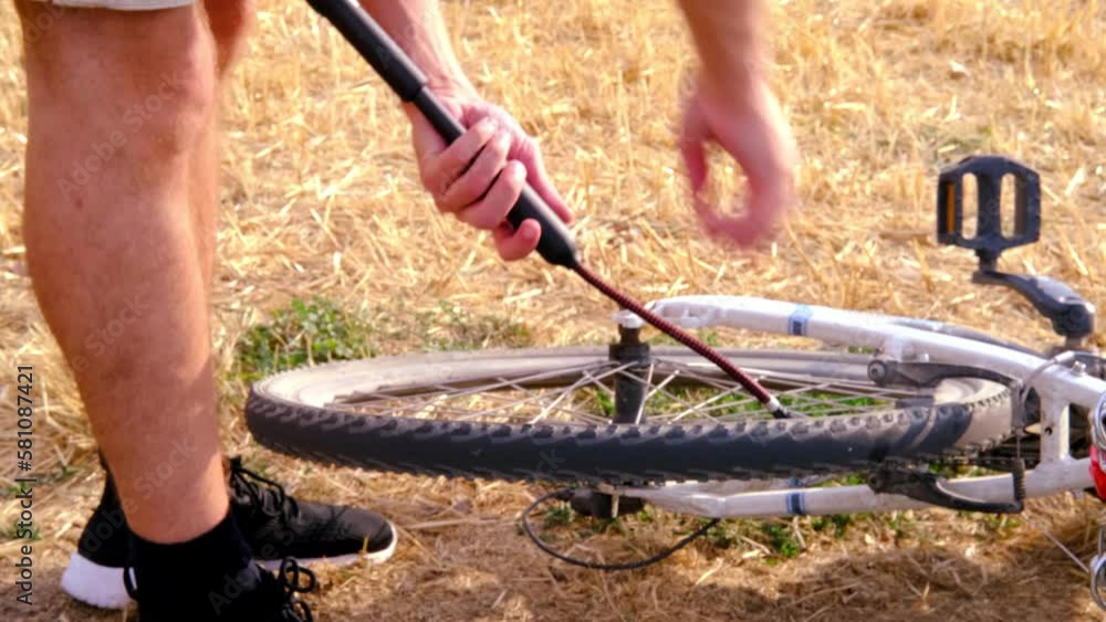 Stockvideo close-up male hands inflate pierced rubber chamber of wheel ...
