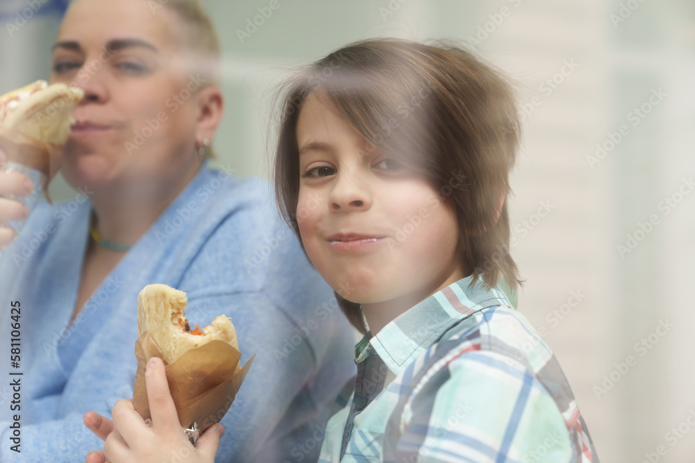 Cute little son and his mother eating Greek gyros in a fast food ...