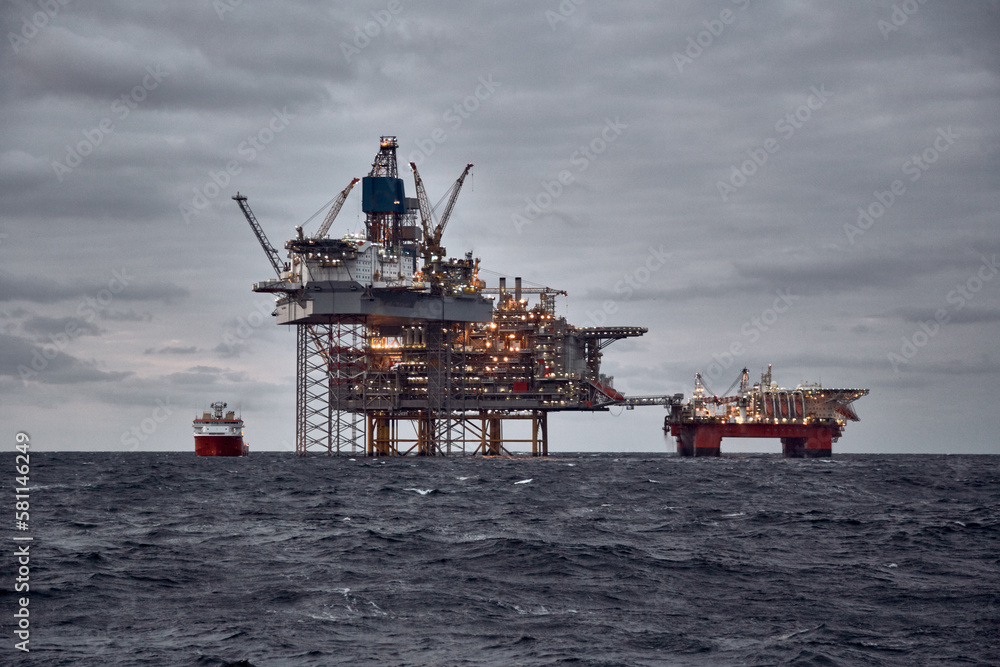 Offshore oil and gas platform with supply vessel doing cargo operations ...