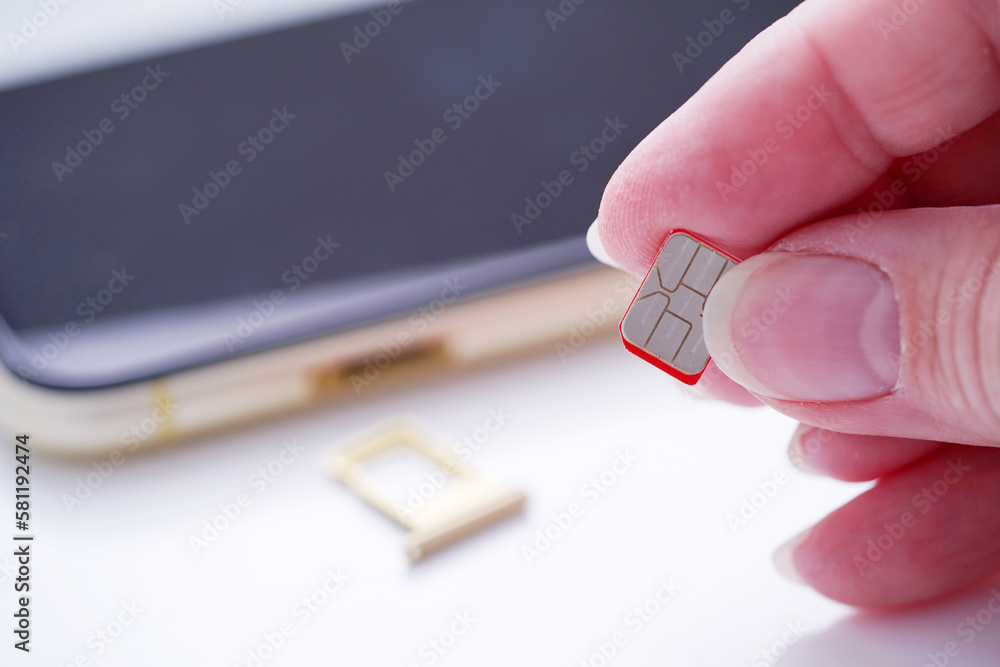 Person inserting a sim card into back of mobile phone, Sim card in tray ...