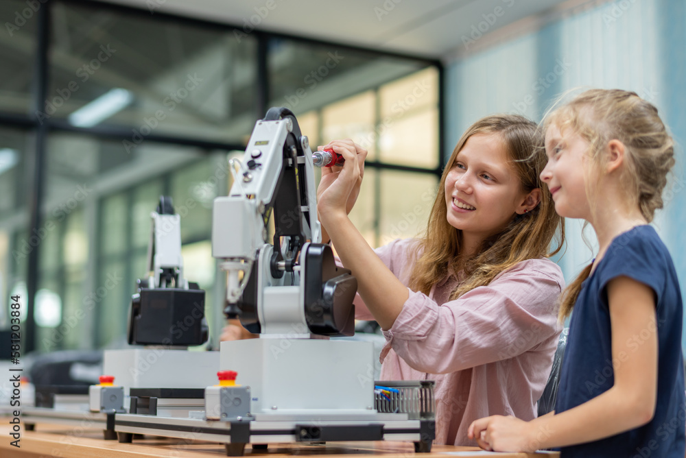 Foto de Kid female teen child enjoy Machine Learning Robot arm is ...