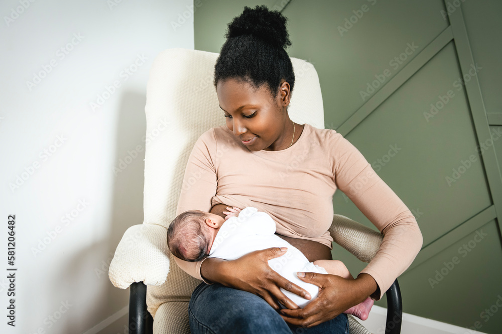 A black woman breast feeding her child girl at home Stock Photo | Adobe ...